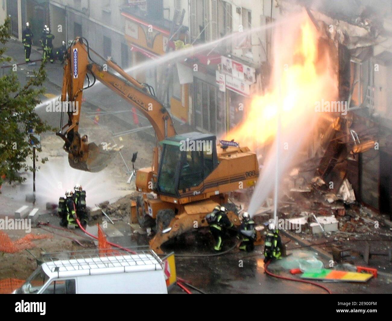 Firefighters work in a street as flames and smoke erupt after a gas ...