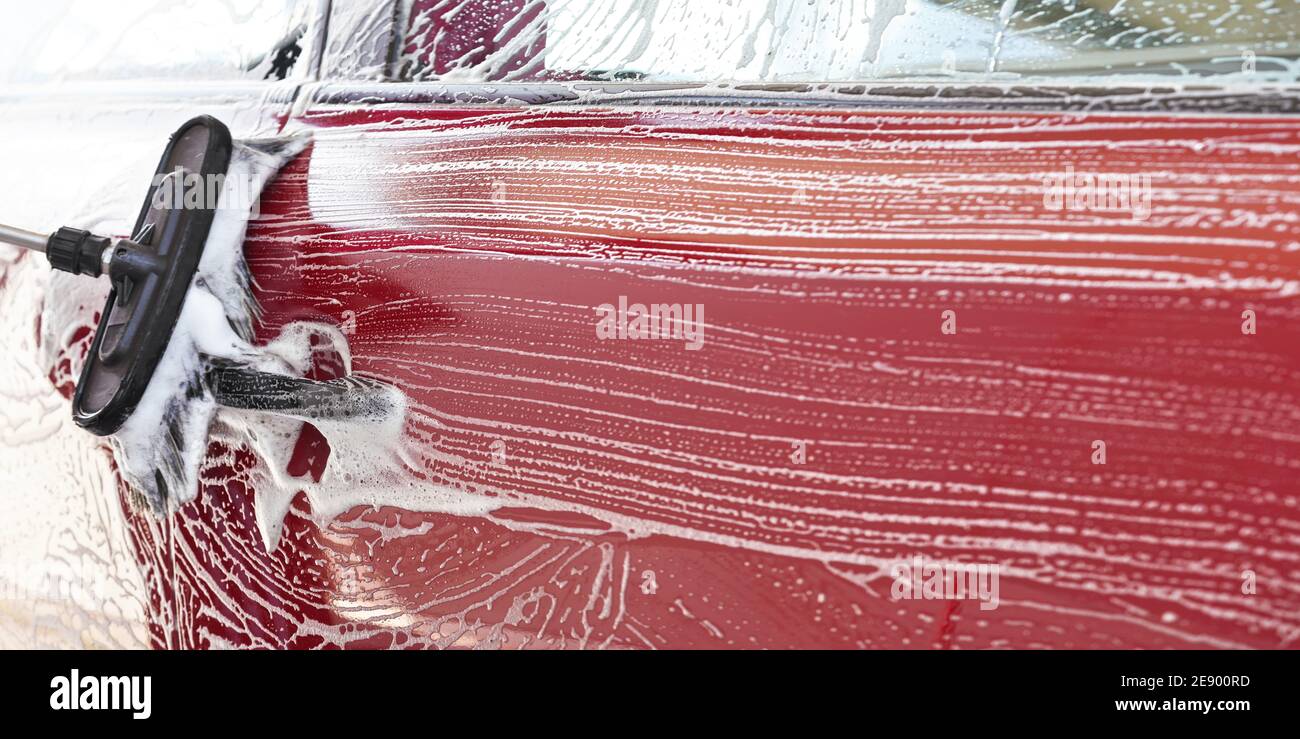Red car washed in self serve carwash , detail on brush leaving strokes ...