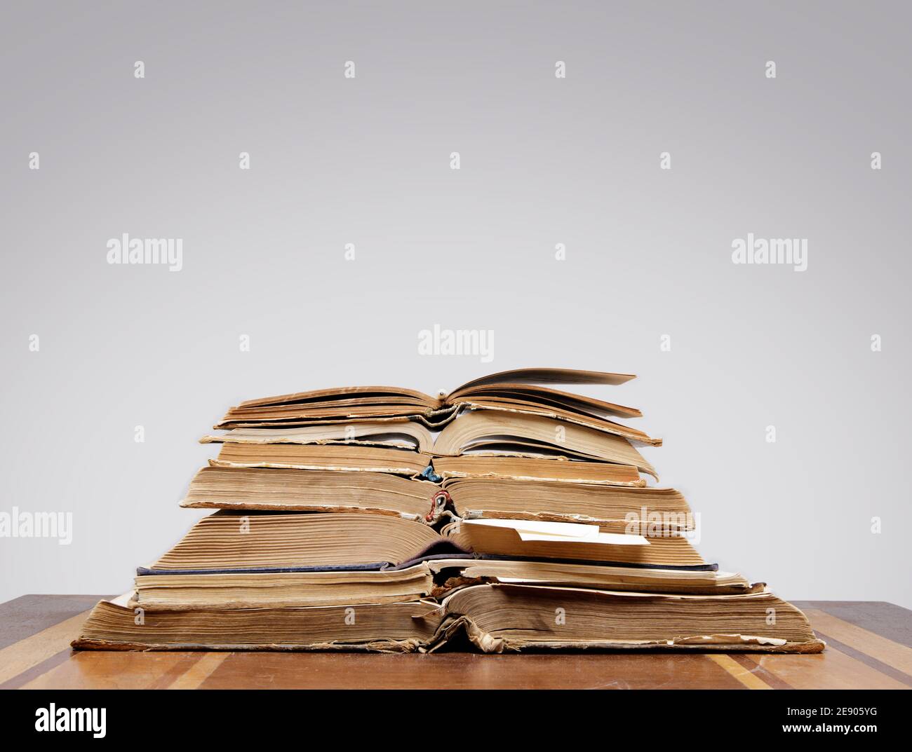 there are many old open books with bookmarks on wooden table on gray ...