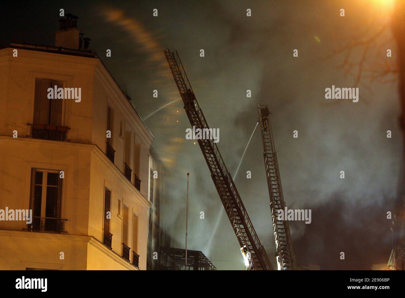 Firefighters work on a scene of a fire caused by a car garage explosion ...