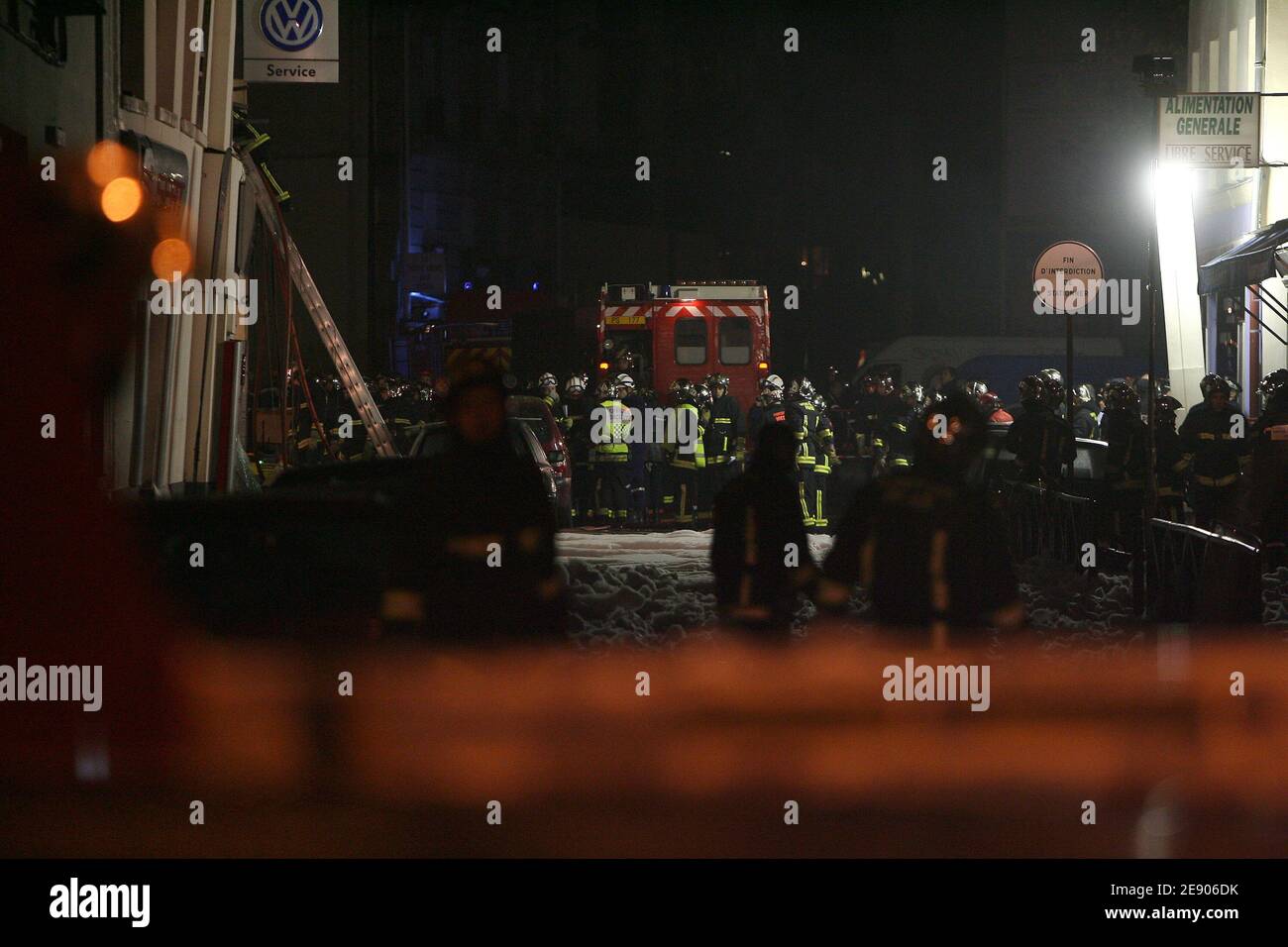 Firefighters work on a scene of a fire caused by a car garage explosion ...