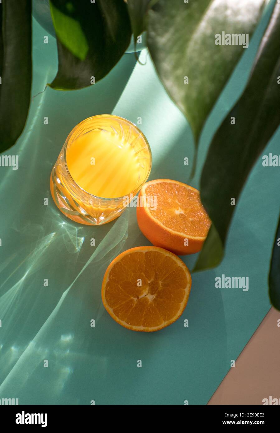 Glass of fresh squeezed orange juice isolated on turquoise blue ...