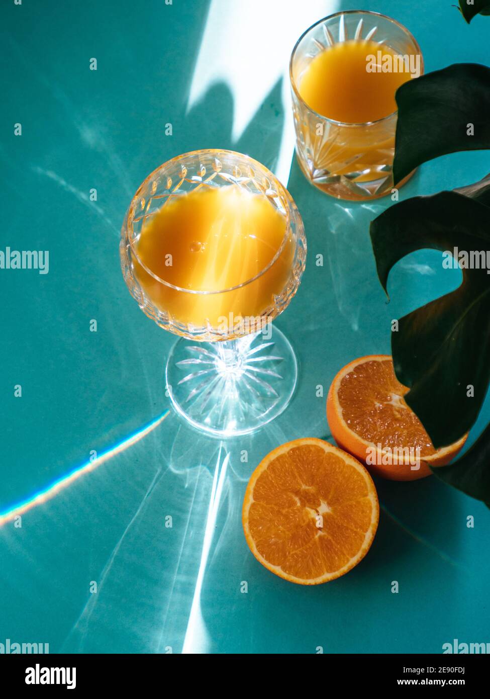 Glass of fresh squeezed orange juice isolated on turquoise blue ...