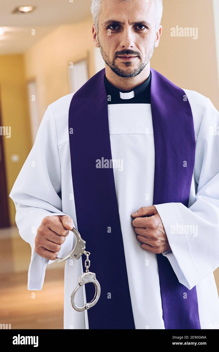 Catholic priest with handcuffs. Church and crime Stock Photo - Alamy