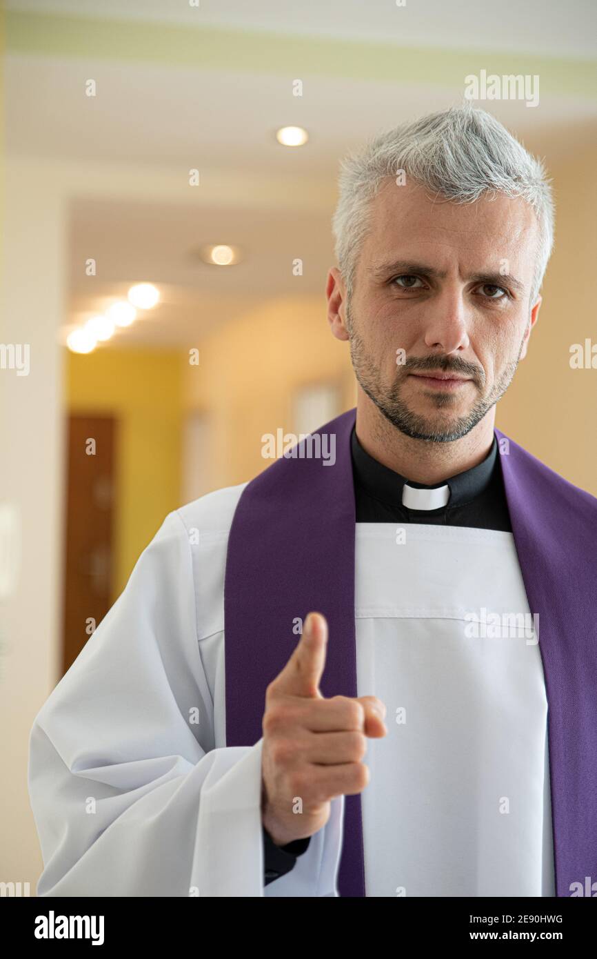 Priest prays and threatens with his finger Stock Photo - Alamy