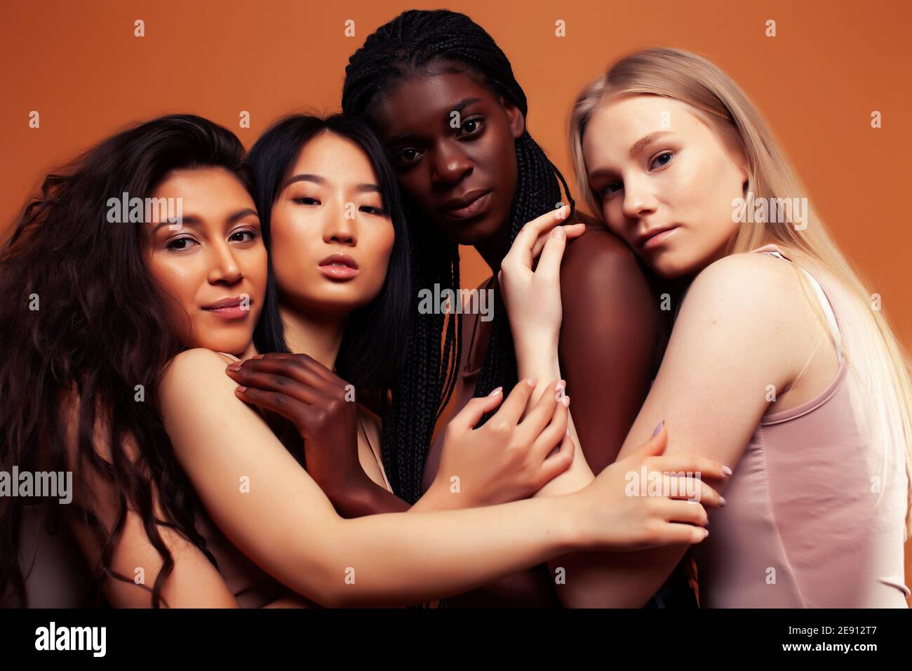 young pretty asian, caucasian, afro woman posing cheerful together on brown background ...