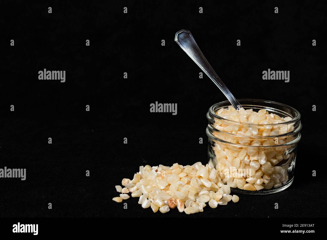 Broken white corn seeds in a glass jar on a black surface Stock Photo ...