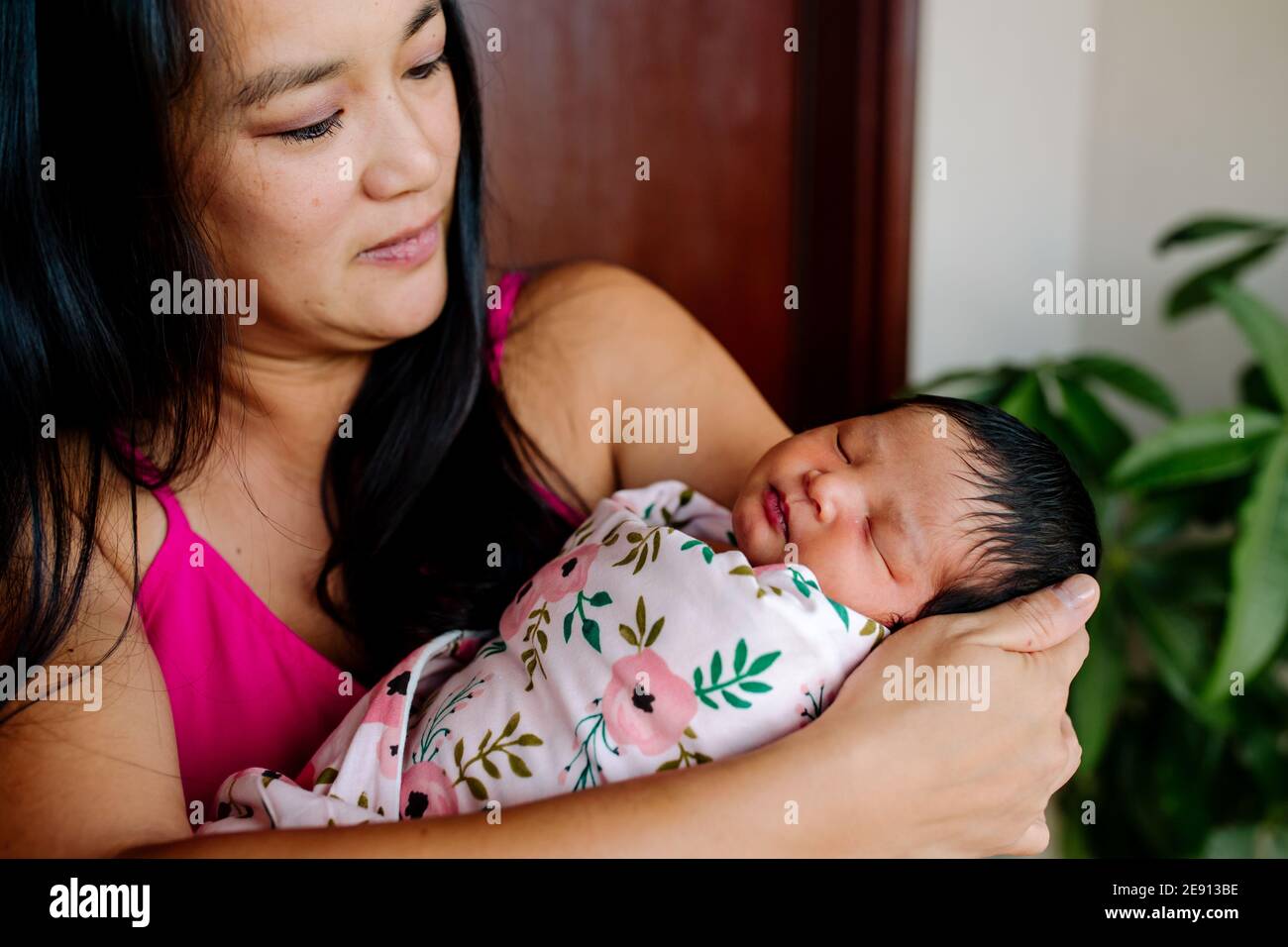 Beautiful mother cradles swaddled newborn baby Stock Photo - Alamy