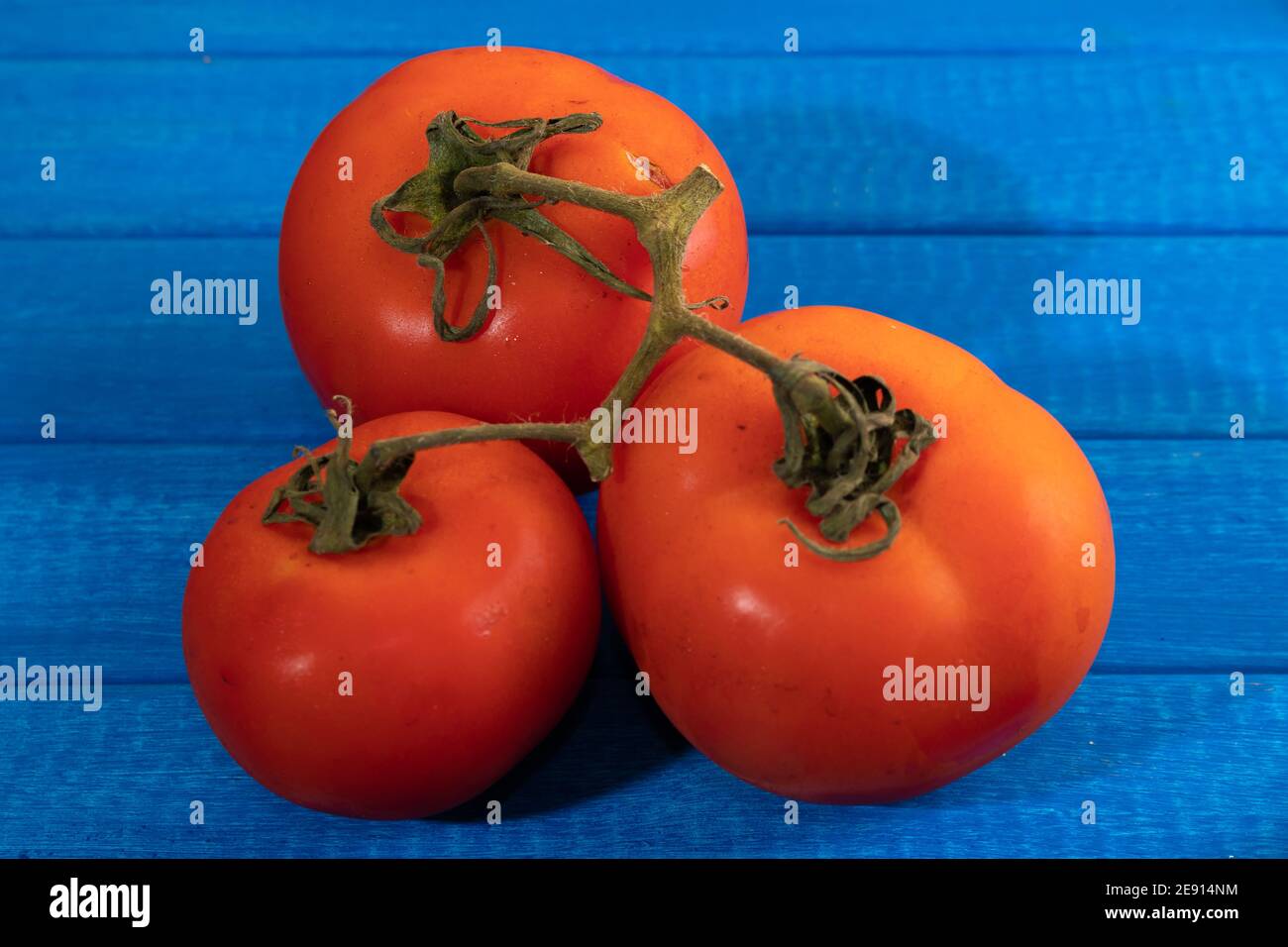 Spectacular bunch of ripe organic tomatoes on a light blue table Stock ...