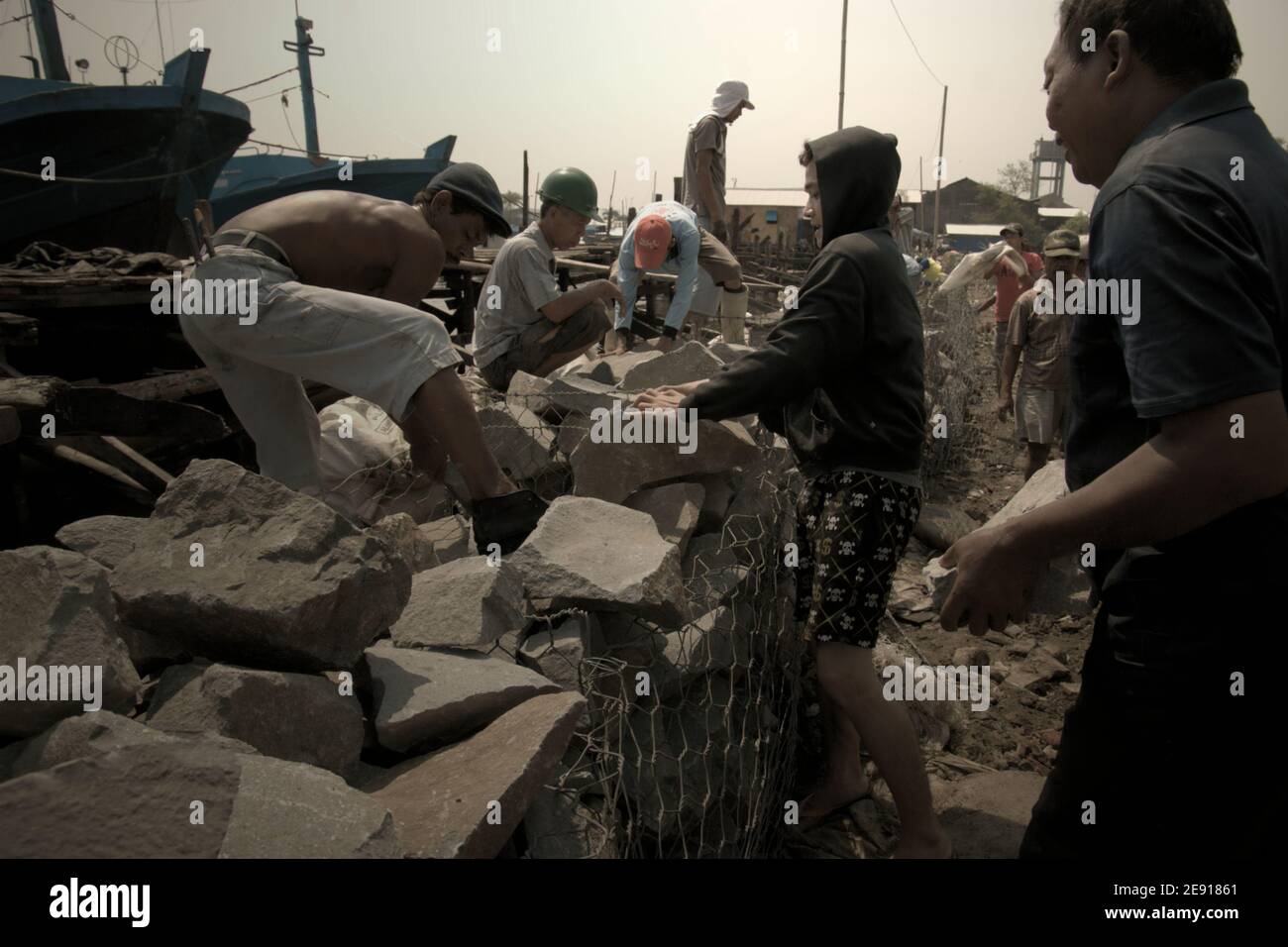 Coastal community working together with workers to build a coastal ...