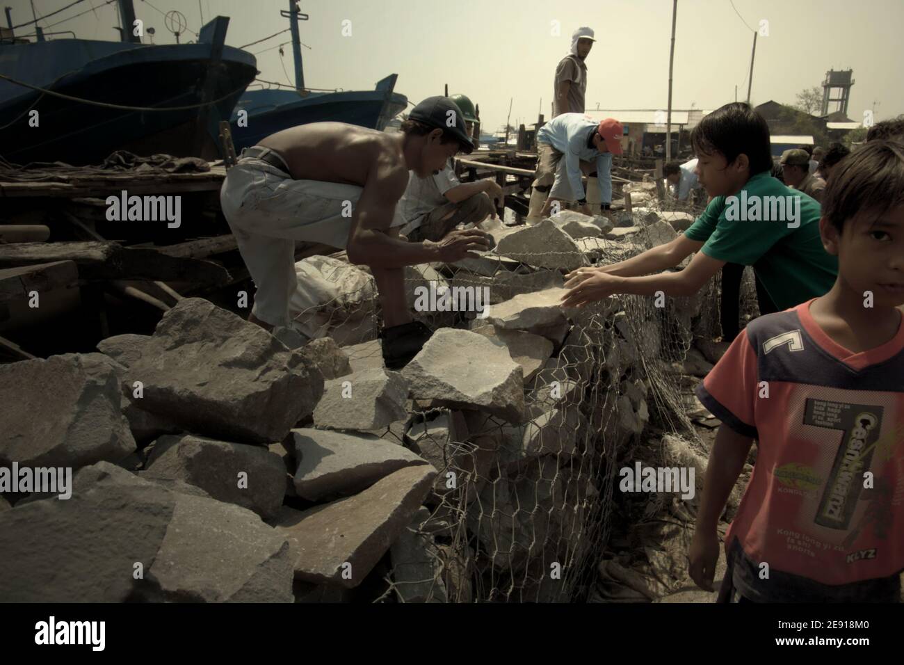 Coastal community working together with workers to build a coastal ...