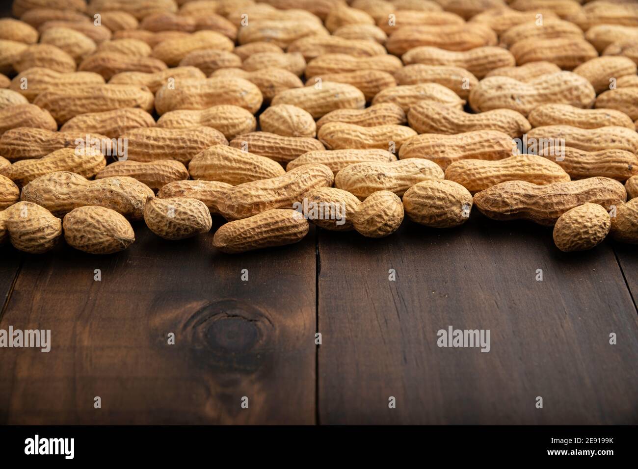 Unpeeled peanuts on wooden table background with copy space. (arachis ...