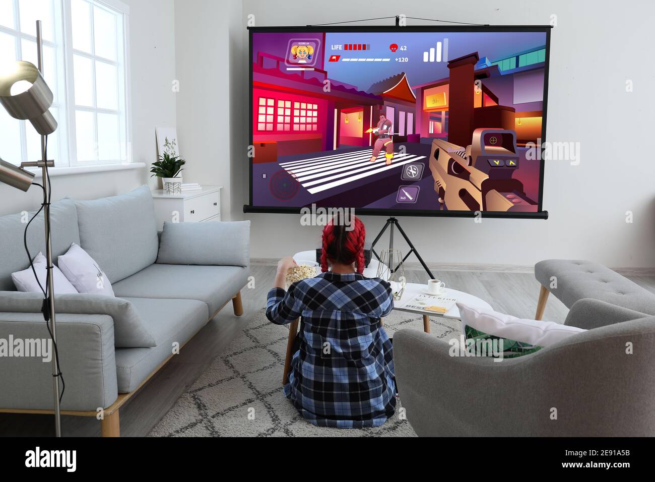 Young woman playing video games on big screen at home Stock Photo - Alamy