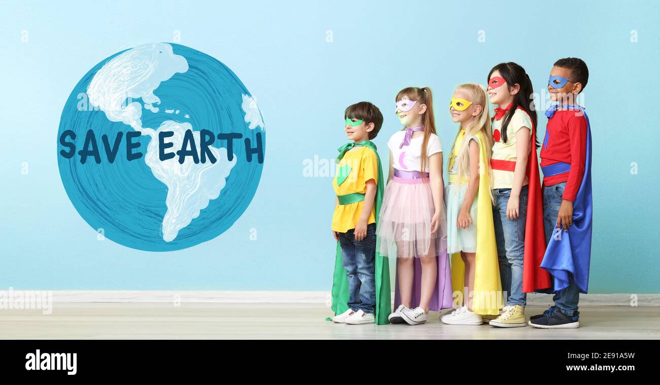 Cute little children dressed as superheroes near drawing of planet on ...