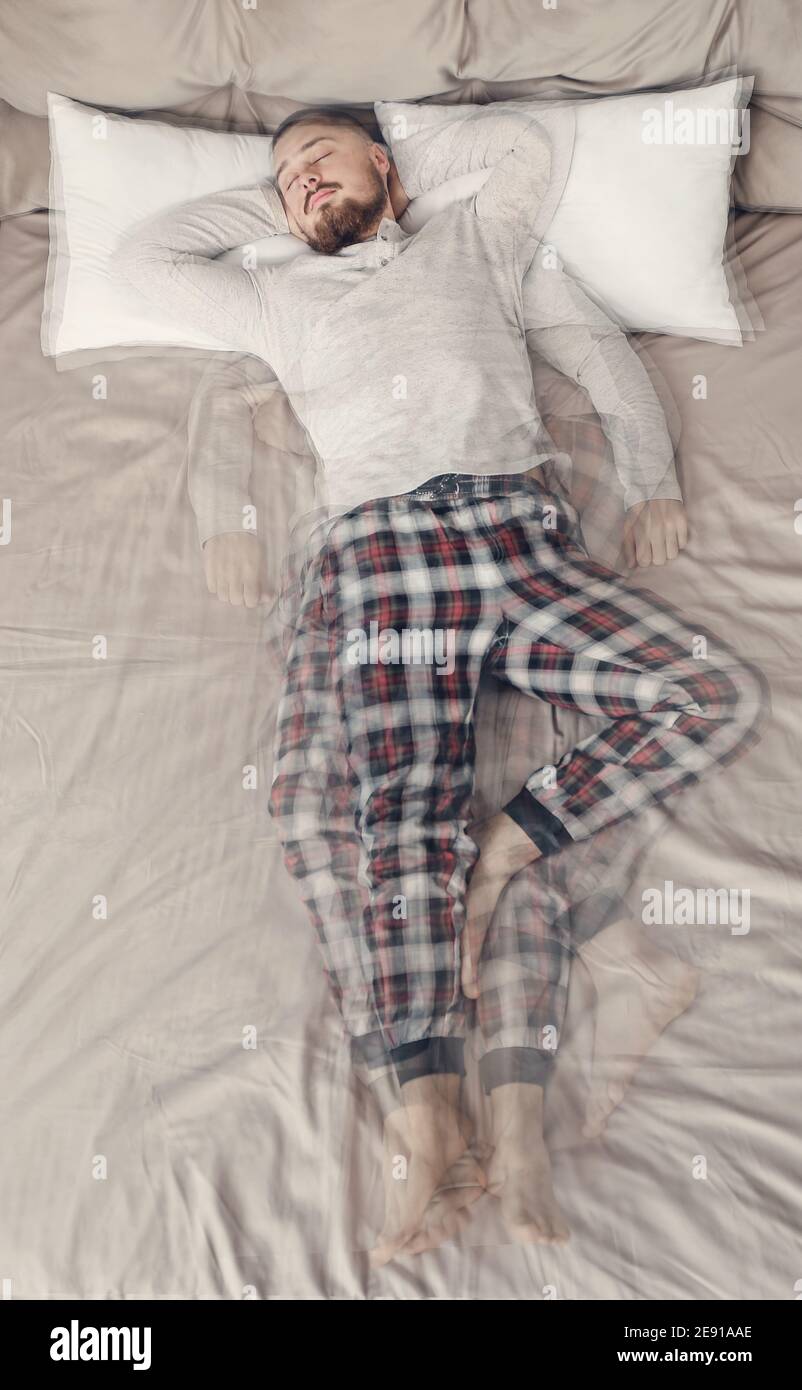 Man changing positions while sleeping in bed Stock Photo - Alamy