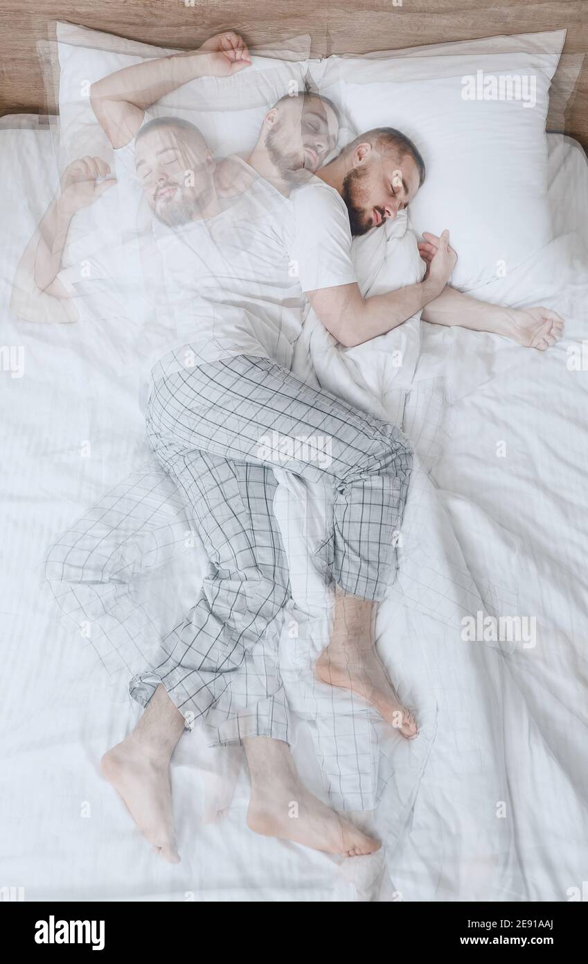 Man changing positions while sleeping in bed Stock Photo - Alamy