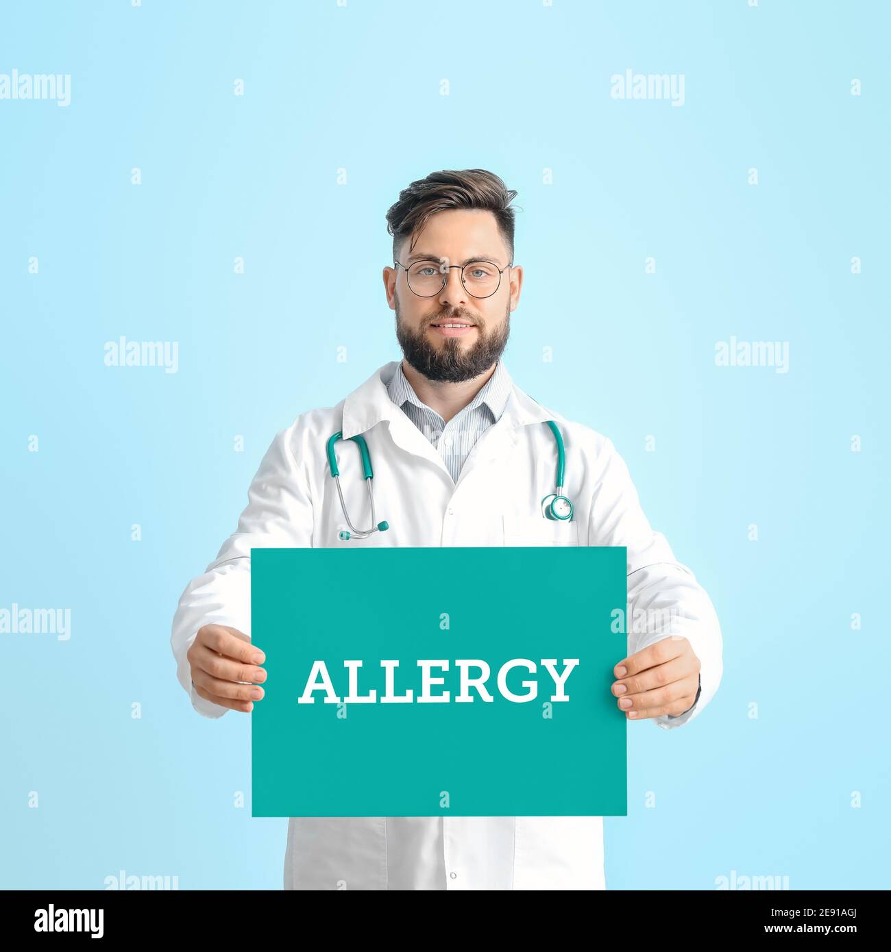 Portrait of male doctor holding poster with text ALLERGY on color ...