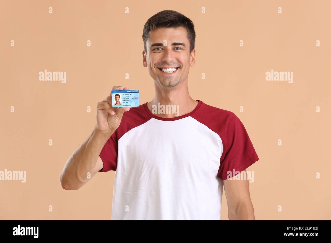 Happy young man with driving license on color background Stock Photo ...