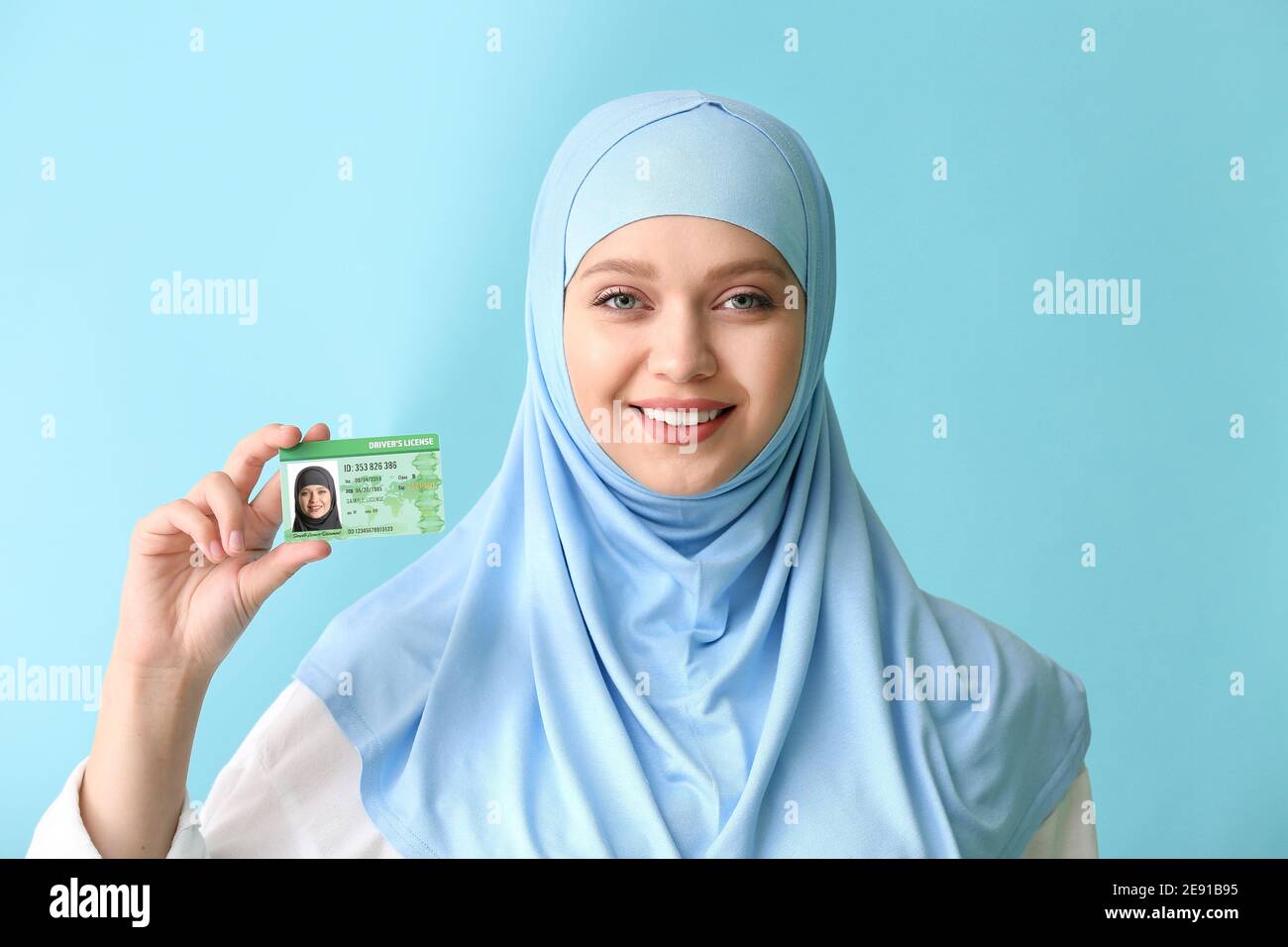 Happy Muslim woman with driving license on color background Stock Photo ...