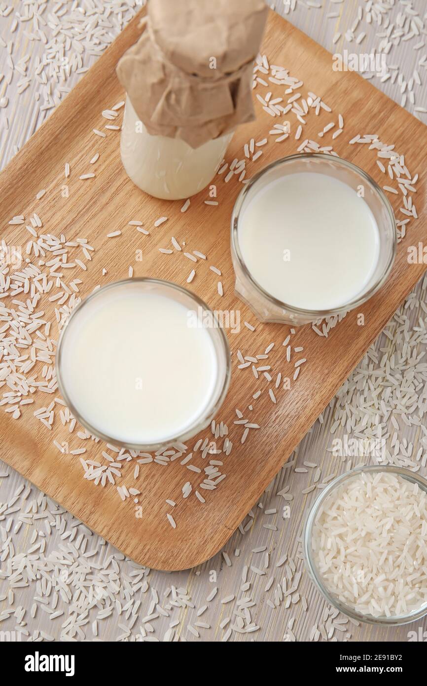 Glasses and bottle of rice milk on table Stock Photo - Alamy