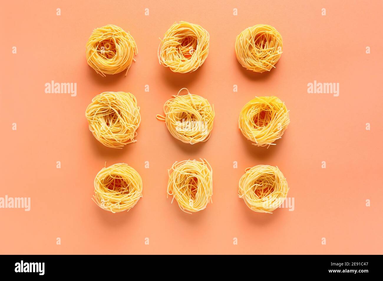 Dry pasta nests on color background Stock Photo - Alamy