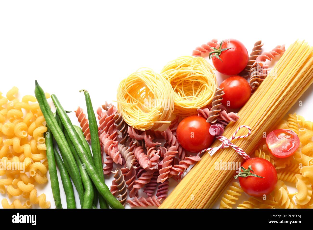 Assortment of dry pasta and vegetables on white background Stock Photo ...