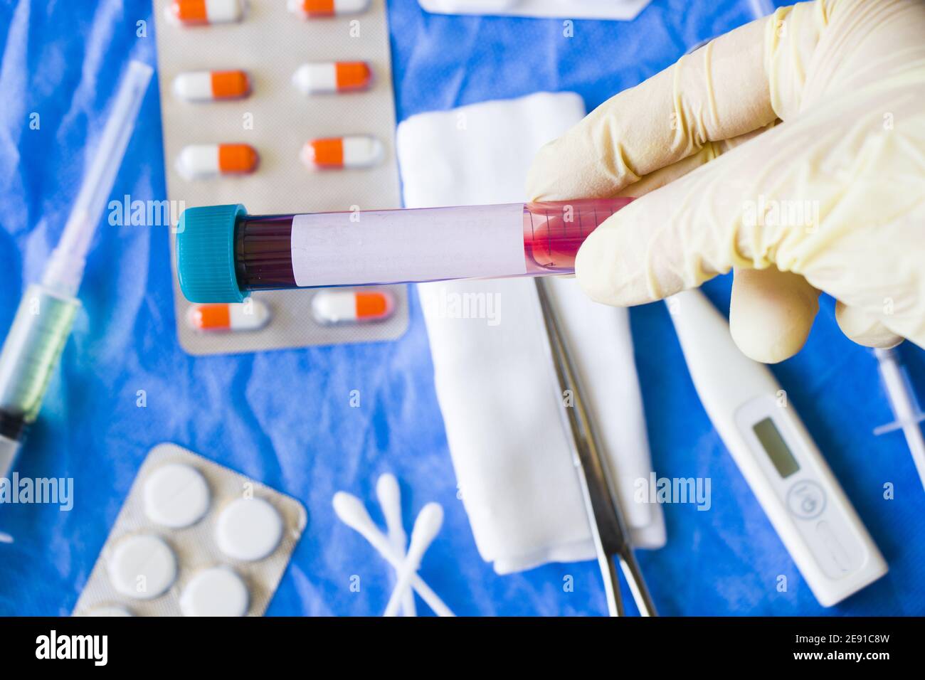 Hand in gloves holding blood test tube specimen with laboratory ...