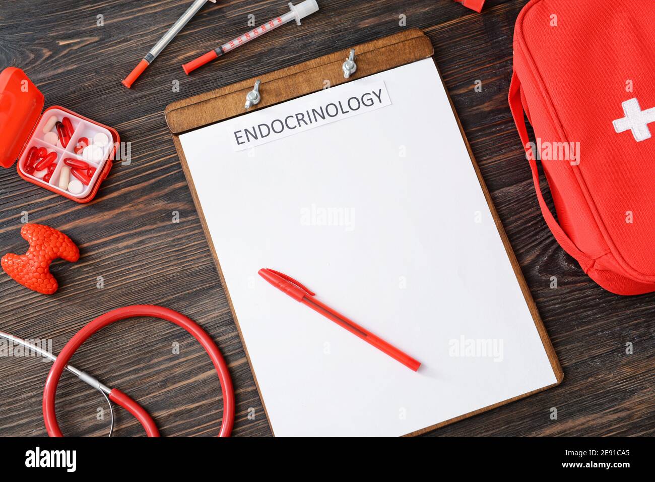 Clipboard with word ENDOCRINOLOGY, thyroid gland, syringes, stethoscope ...