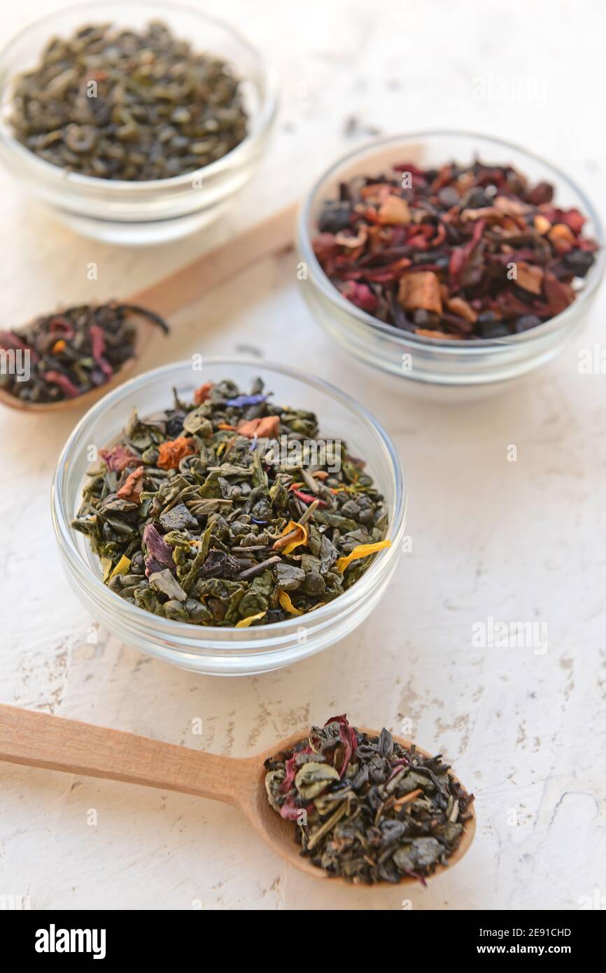 Bowls and spoons with different dry tea leaves on table Stock Photo - Alamy