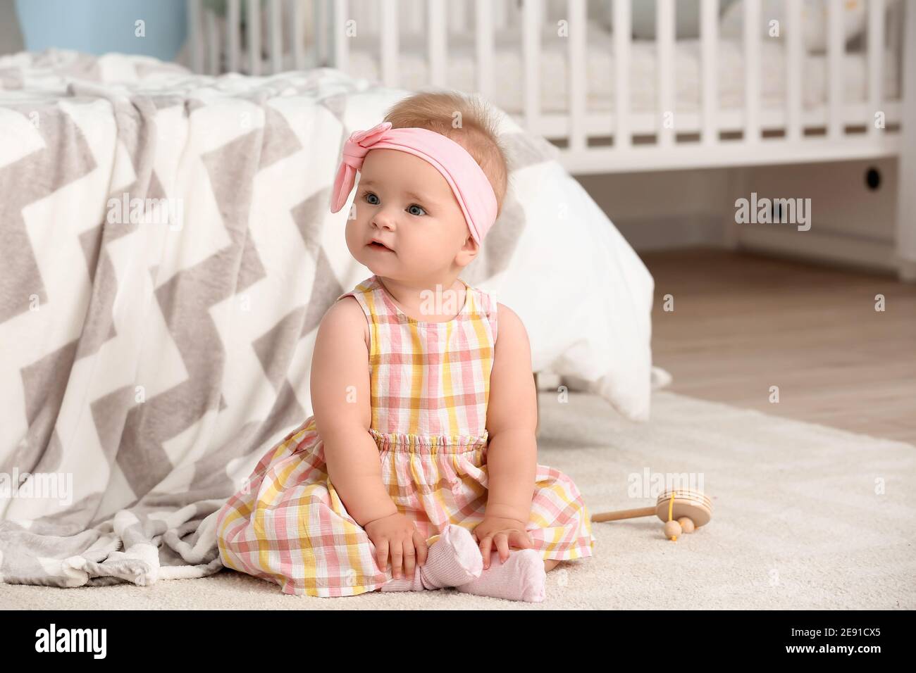Cute little baby sitting on carpet at home Stock Photo - Alamy