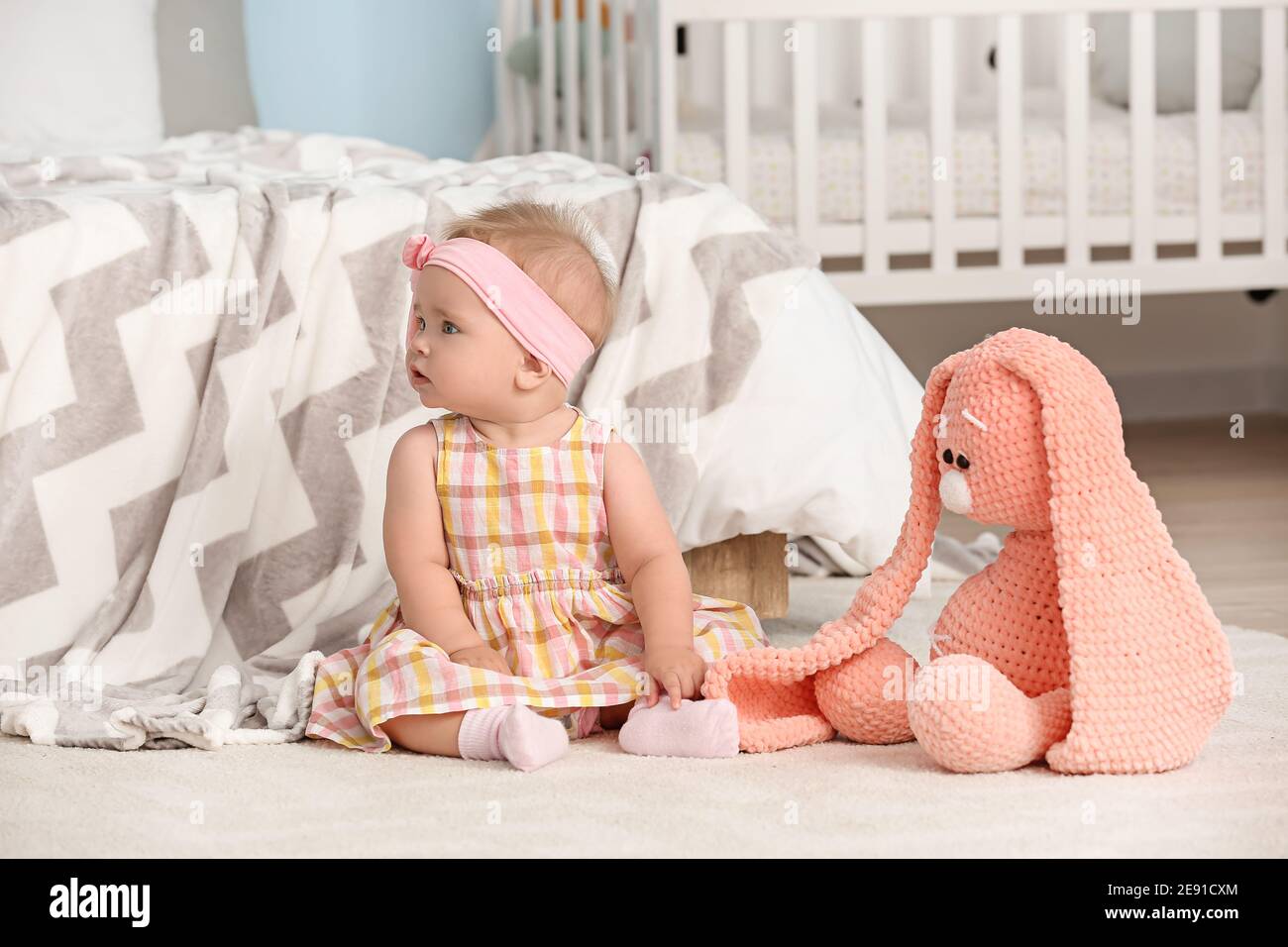 Cute little baby sitting on carpet at home Stock Photo - Alamy