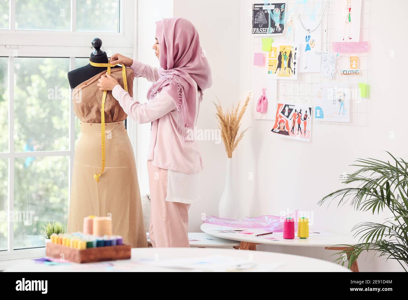 Female Muslim fashion designer working in studio Stock Photo - Alamy