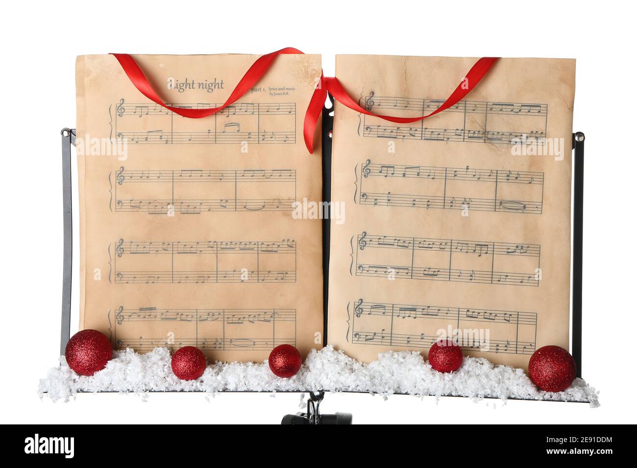 Music sheets with notes and Christmas decor on stand against white ...