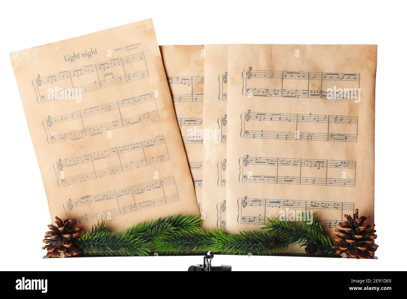 Music sheets with notes and Christmas decor on stand against white ...