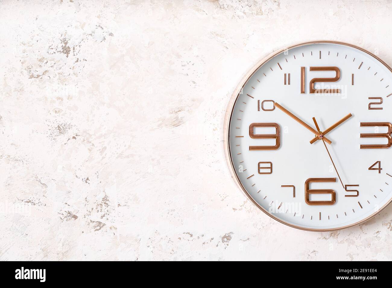 Modern clock hanging on light wall Stock Photo - Alamy