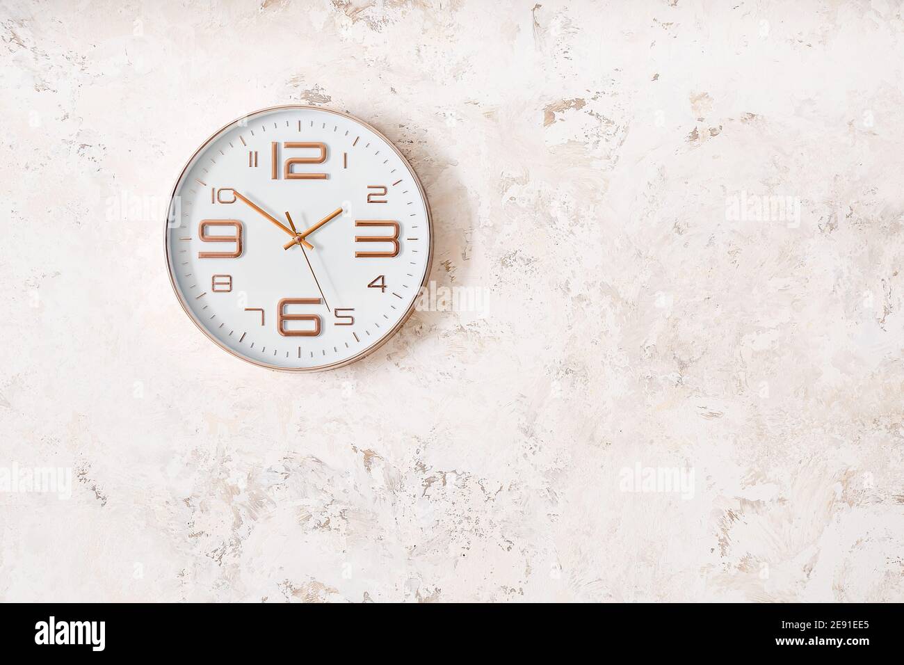 Modern clock hanging on light wall Stock Photo - Alamy