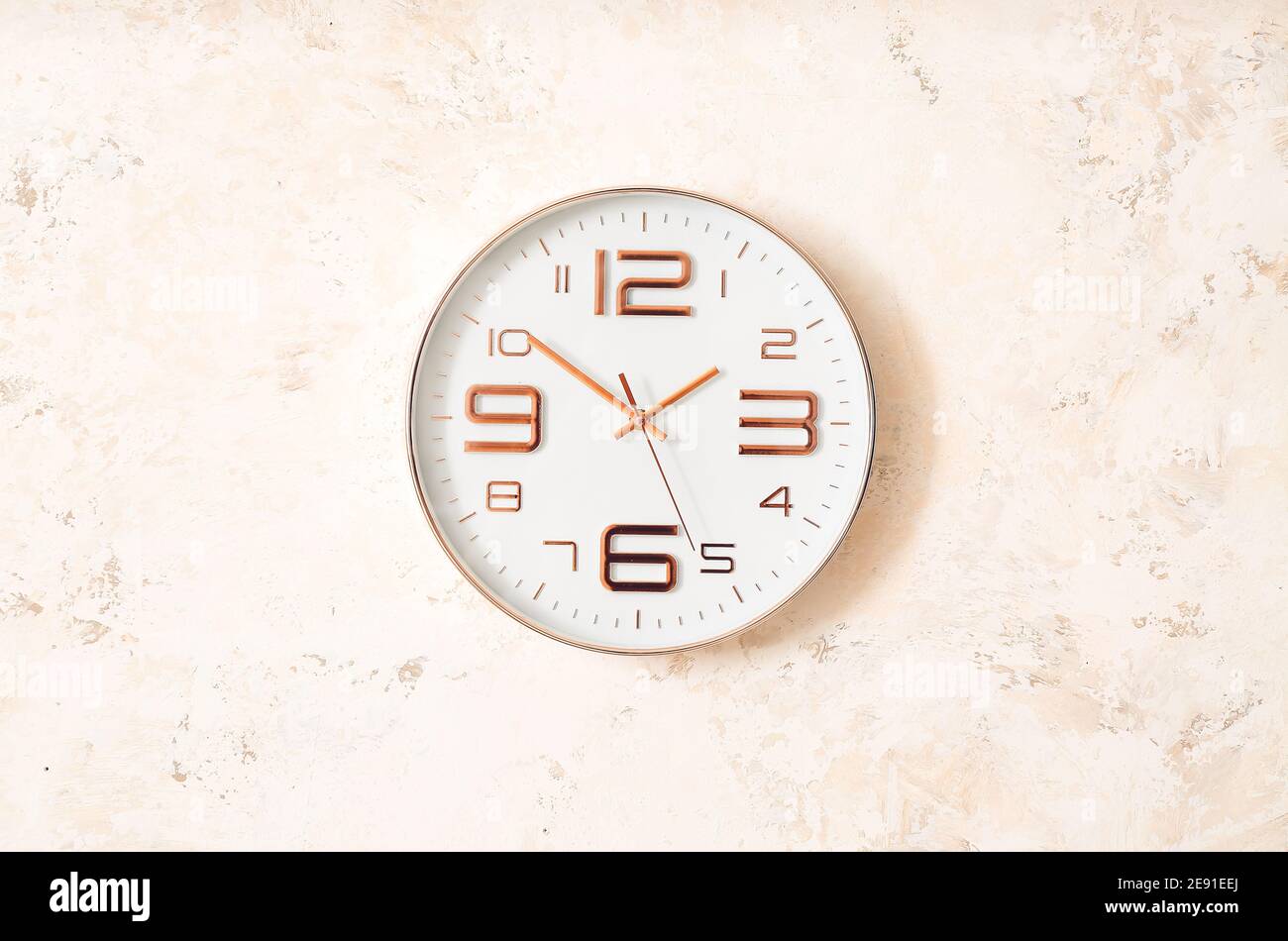 Modern clock hanging on light wall Stock Photo - Alamy
