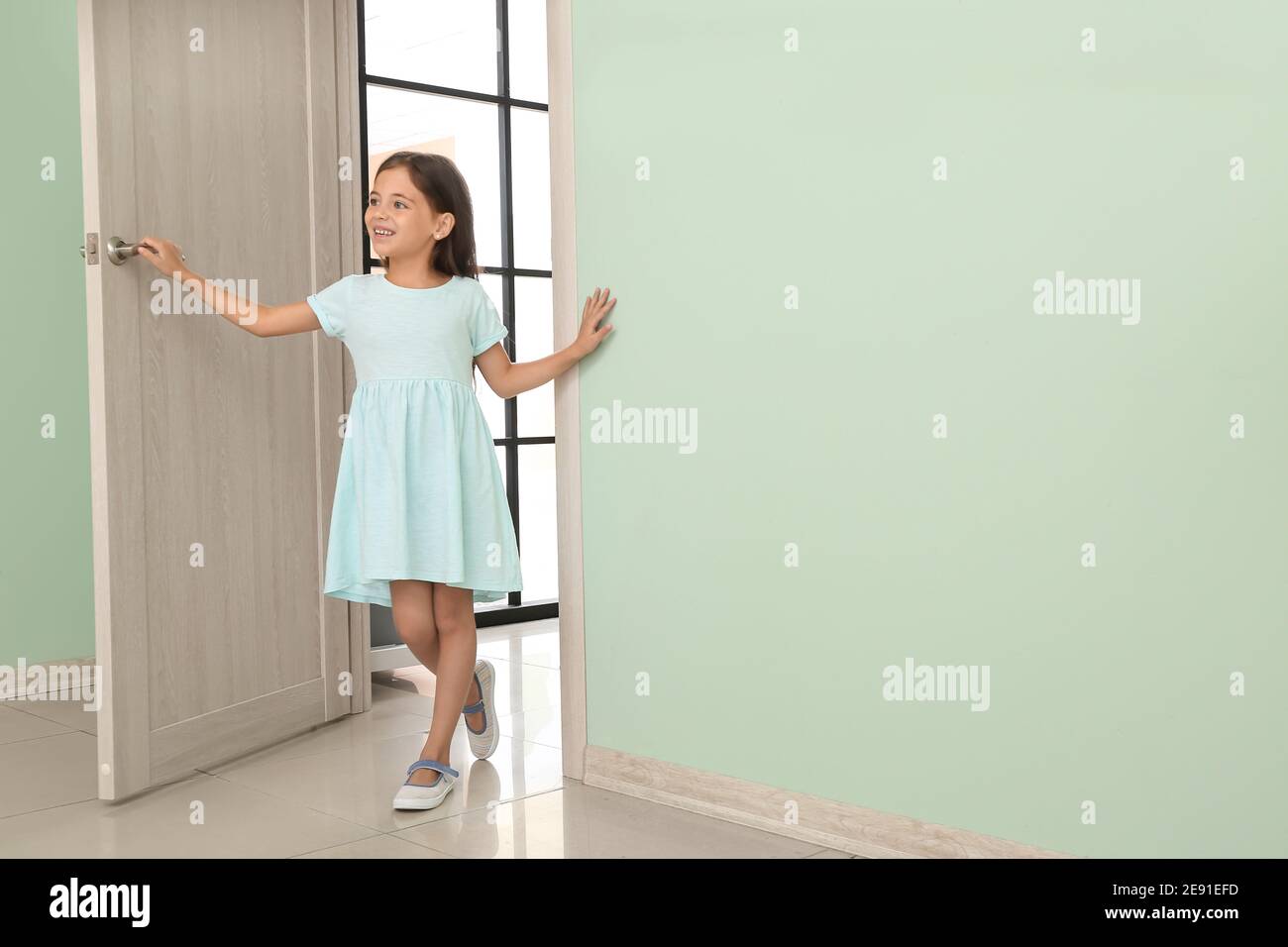 Cute little girl standing in doorway Stock Photo - Alamy