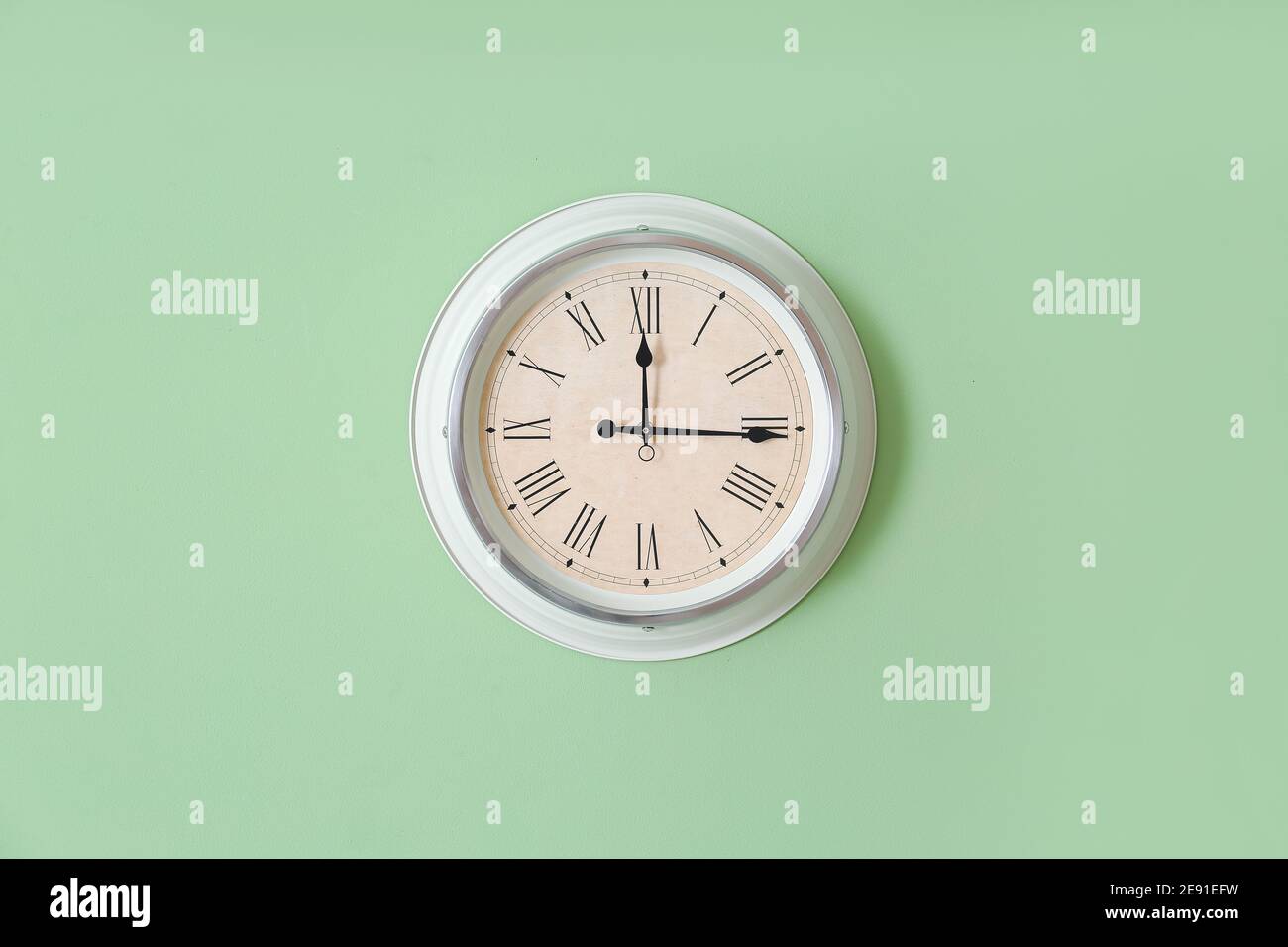 Modern clock hanging on color wall Stock Photo - Alamy