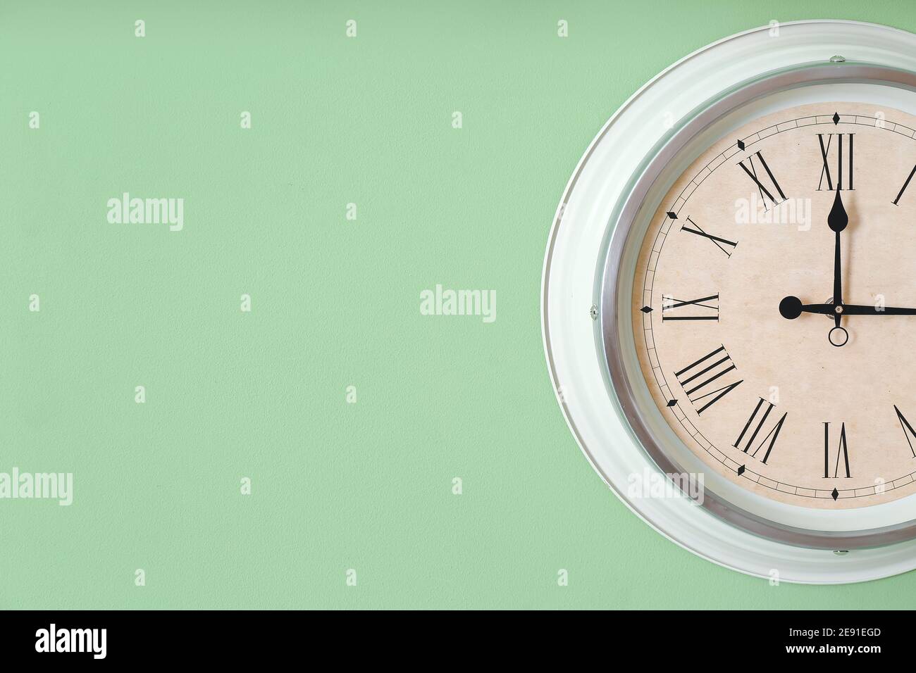 Modern clock hanging on color wall Stock Photo - Alamy