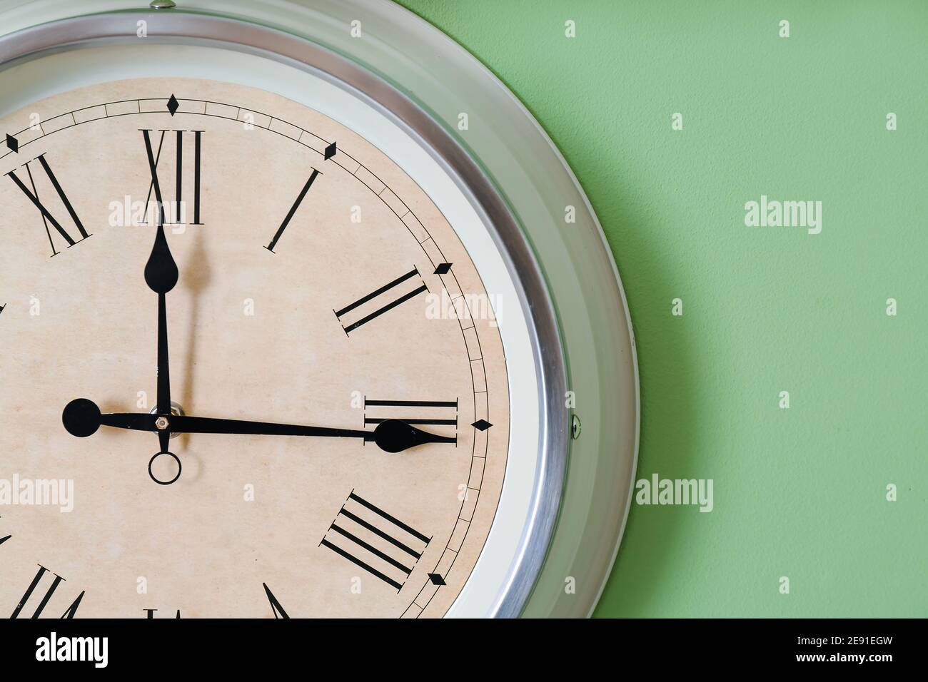 Modern clock hanging on color wall Stock Photo - Alamy