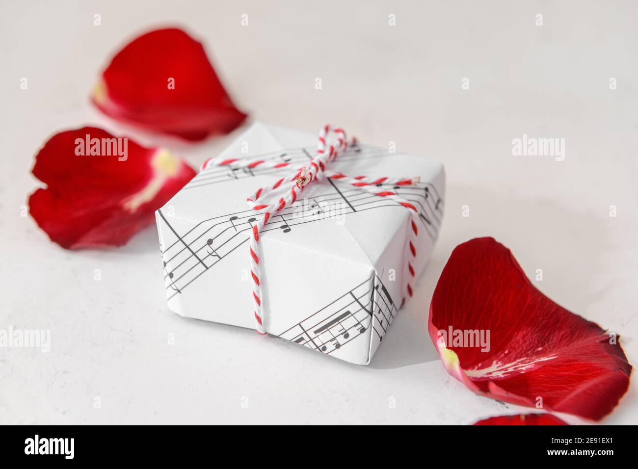 Gift box made of music notes and rose petals on light background Stock ...