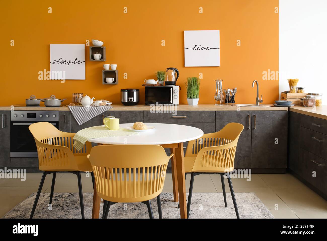 Interior of modern kitchen with dining table Stock Photo - Alamy