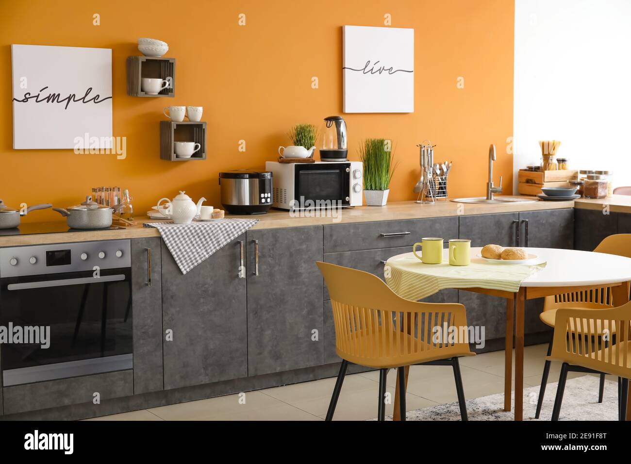 Interior of modern kitchen with dining table Stock Photo - Alamy