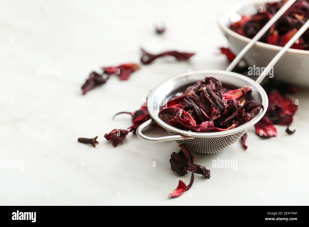 Sieve with dry hibiscus tea on white background Stock Photo - Alamy