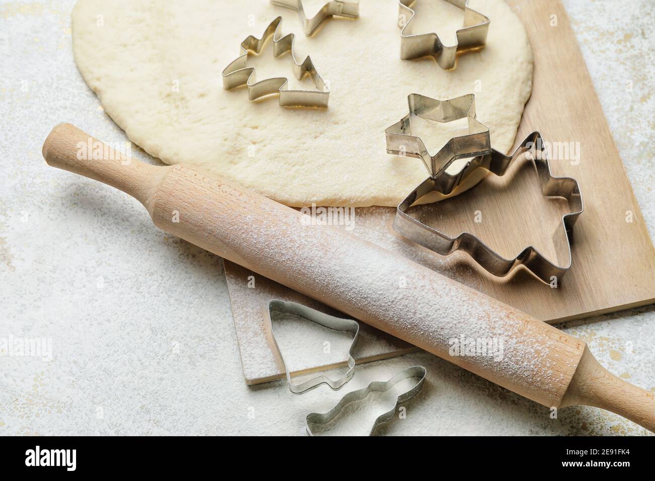 Cookie cutters, dough and rolling pin on light background Stock Photo ...
