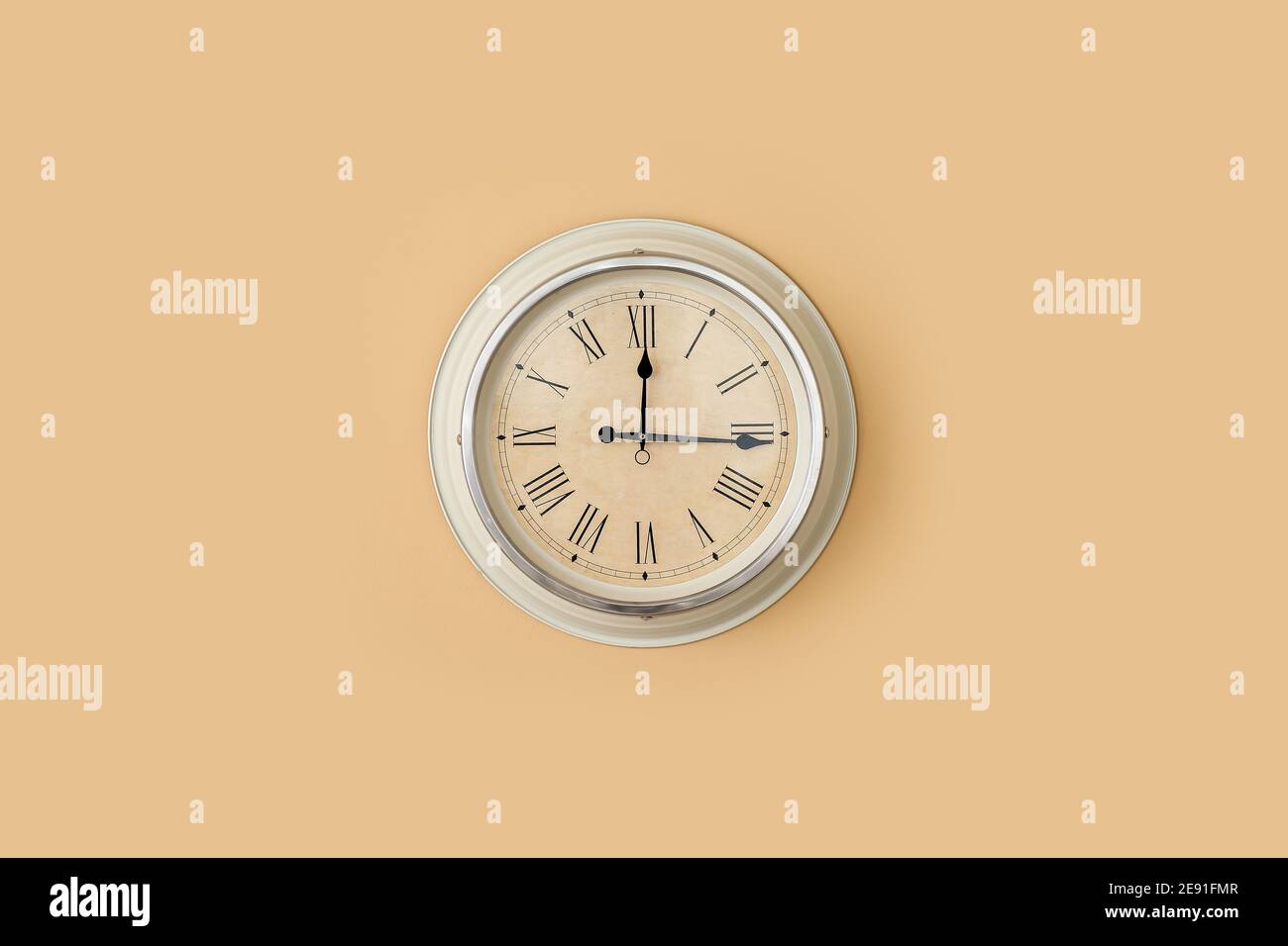 Modern clock hanging on color wall Stock Photo - Alamy