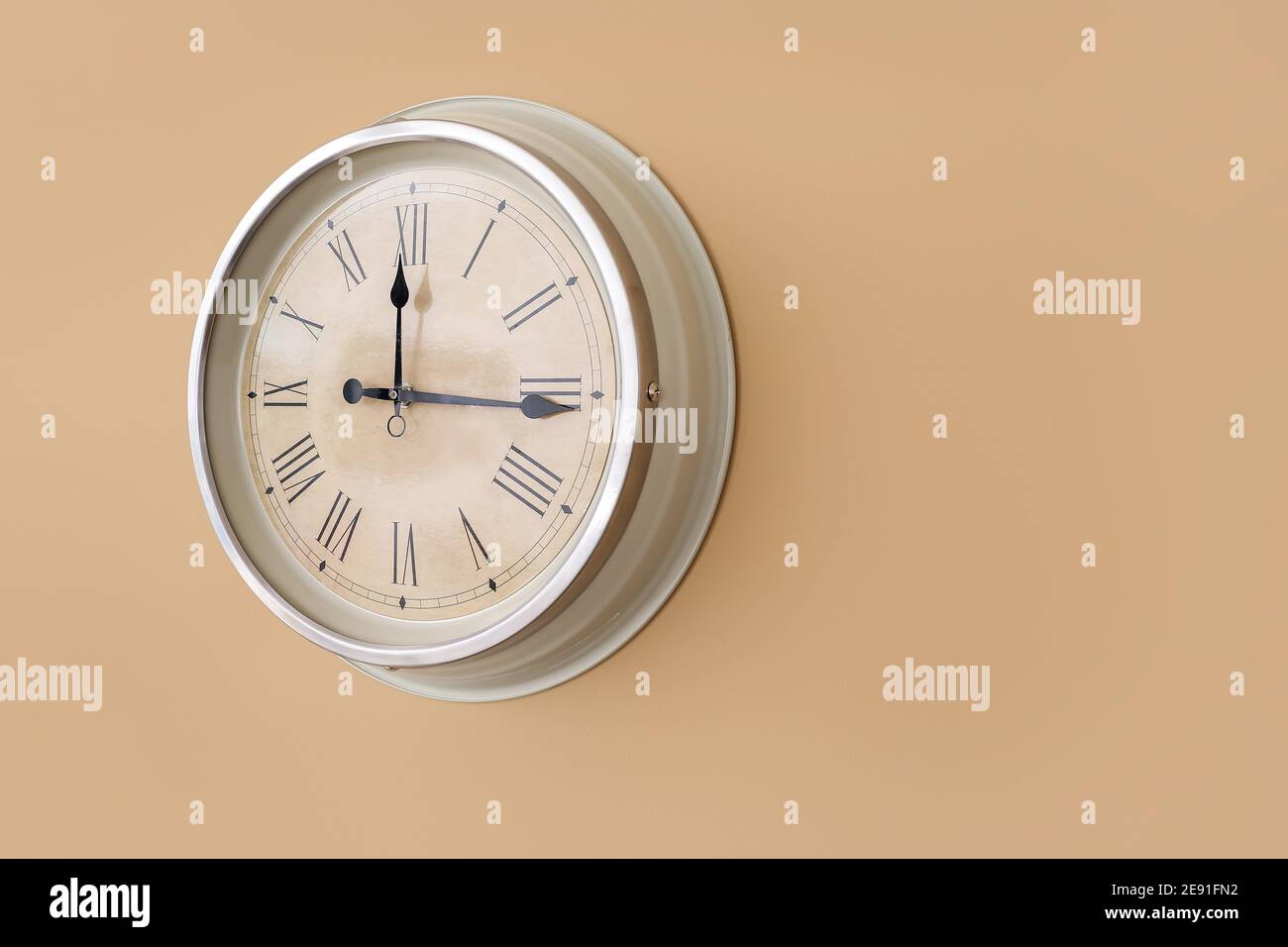 Modern clock hanging on color wall Stock Photo - Alamy