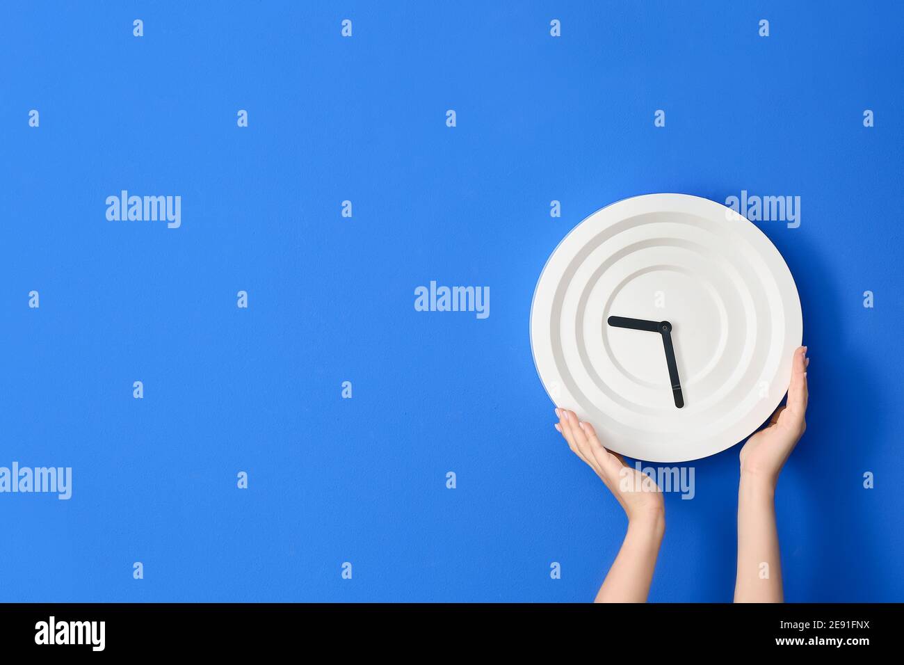 Woman hanging hands of clock hi-res stock photography and images - Alamy