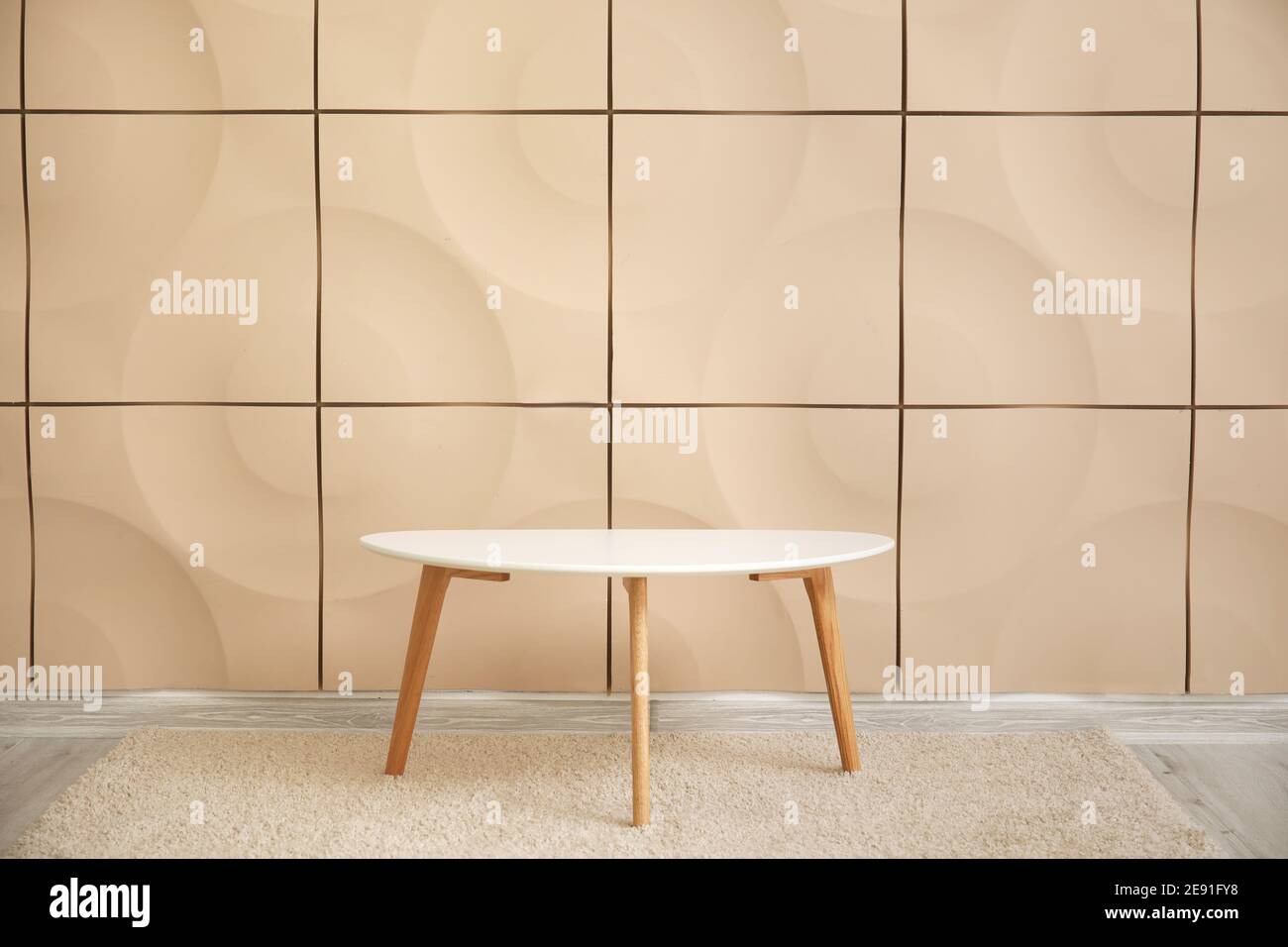 Stylish table near wall in room Stock Photo - Alamy